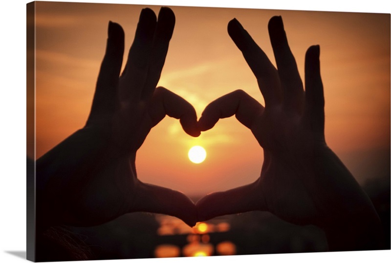Sunset viewed through fingers forming heart | Great Big Canvas