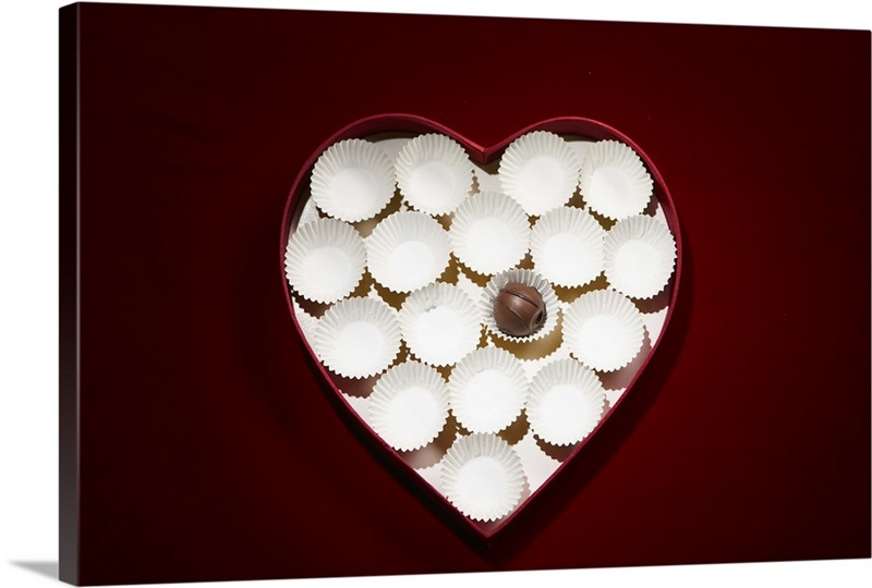 Chocolate bon-bon and empty wrappers in heart shaped box | Great Big Canvas