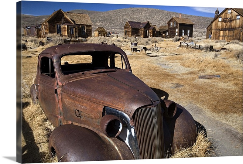 Old rusty car surrounded by abandoned houses | Great Big Canvas