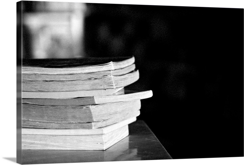 Pile of paperback books on desk in school library. | Great Big Canvas