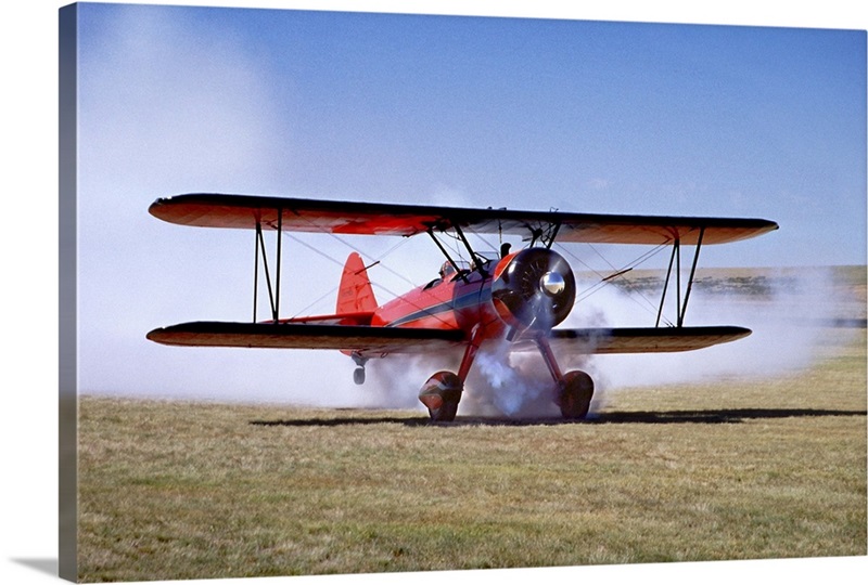 Red Stearman bi-plane taking off with air show smoke | Great Big Canvas