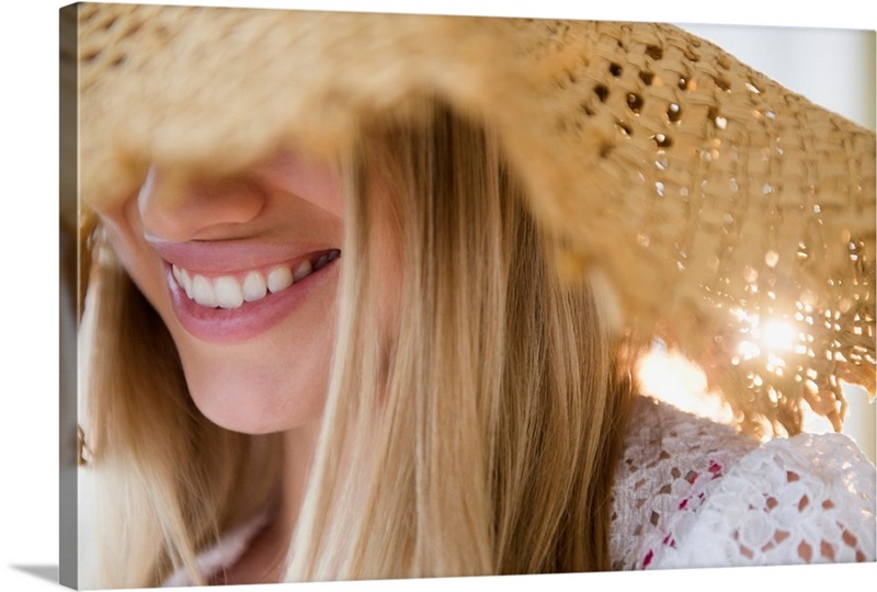 Smiling young woman wearing straw hat | Great Big Canvas