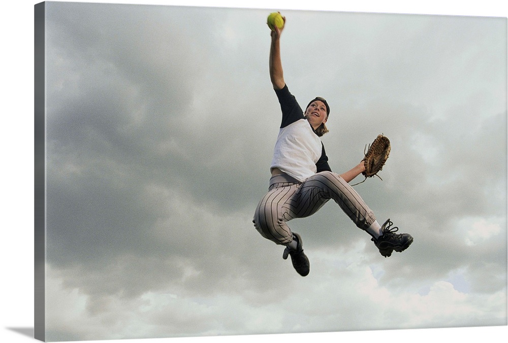 Teenage girl jumping in the air to catch a ball | Great Big Canvas
