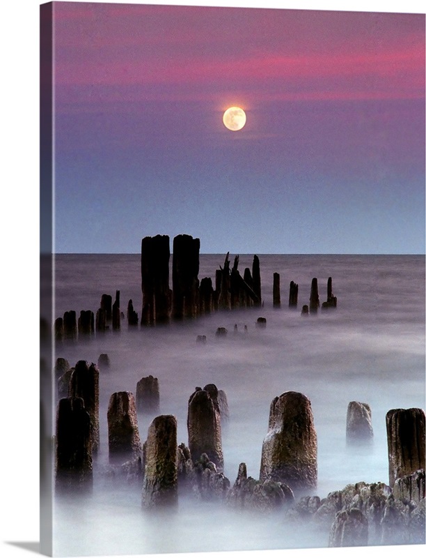 The full moon rises over Lake Michigan as rolling waves wash over the ...