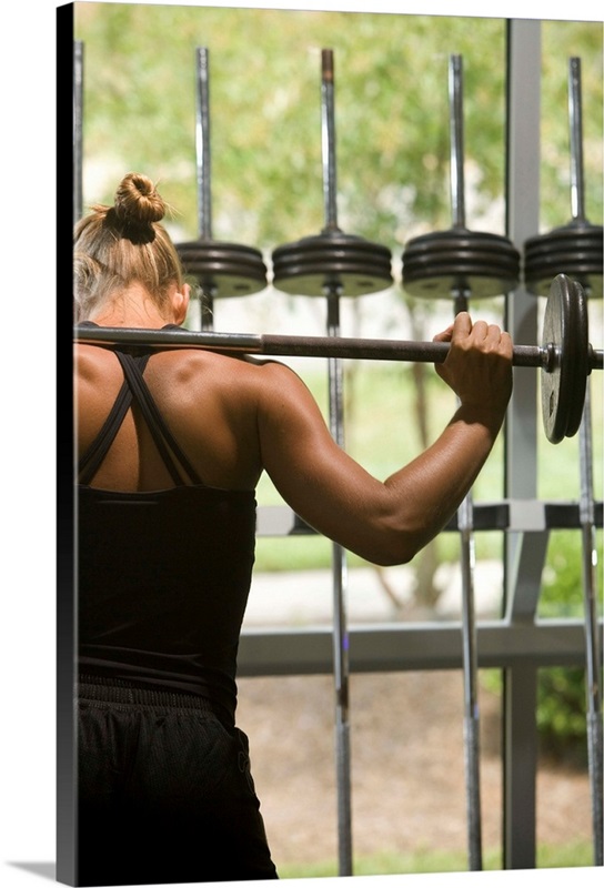 Young woman exercising with barbell, rear view | Great Big Canvas