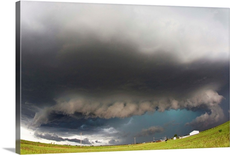 A thunderstorm with dark skies and illuminated a blue rain/hail shaft ...