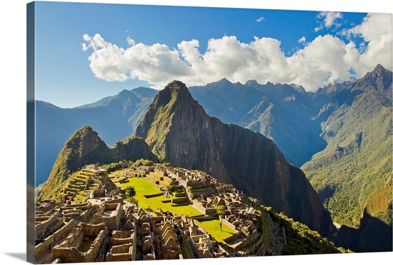 Sun shining through the Andes mountains onto Machu Picchu at sunset ...
