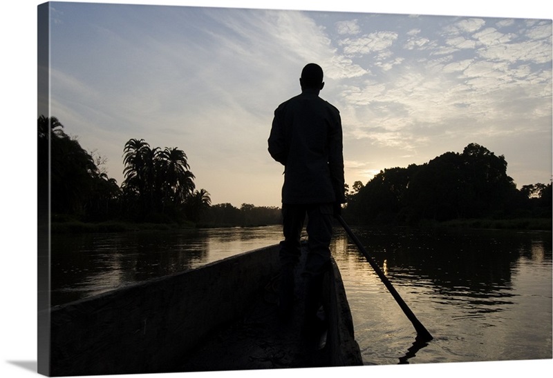 Man paddling canoe down Lekoli River, Democratic Republic of the Congo ...