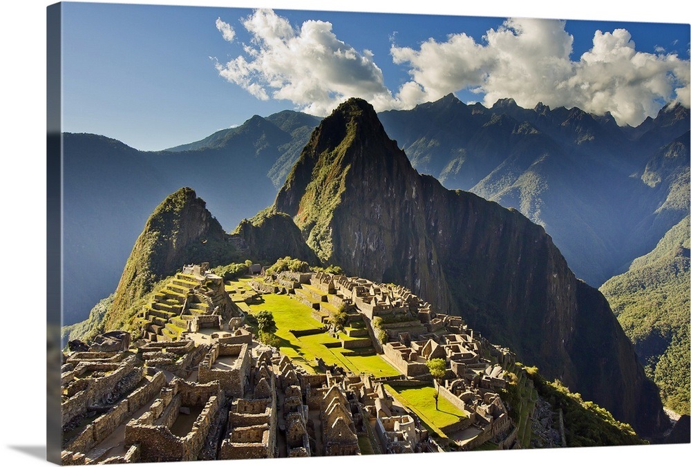 Sun shining through the Andes mountains onto Machu Picchu at sunset ...