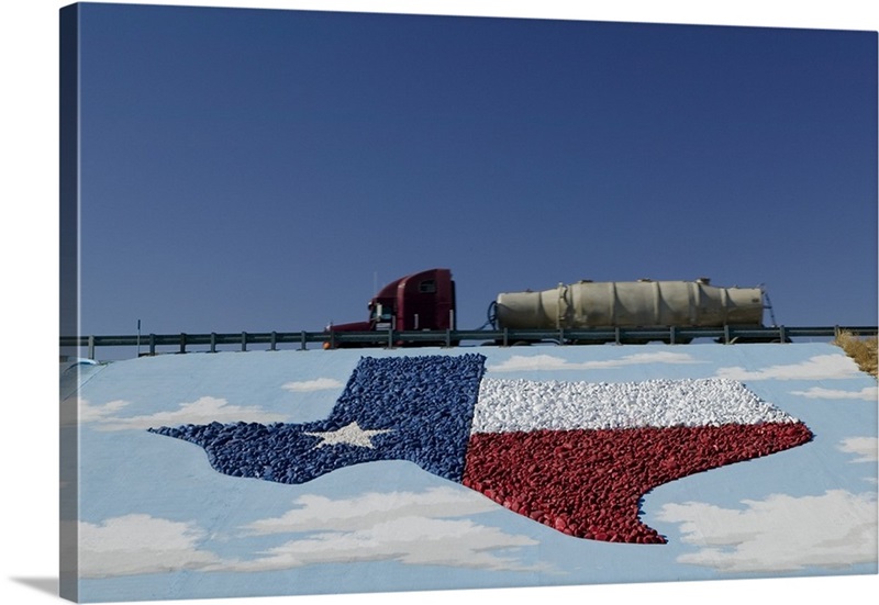 Low angle view of truck and map of Texas on the slope beside a highway ...