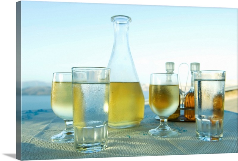 Wine glasses with a wine bottle on a table, Santorini, Cyclades Islands ...