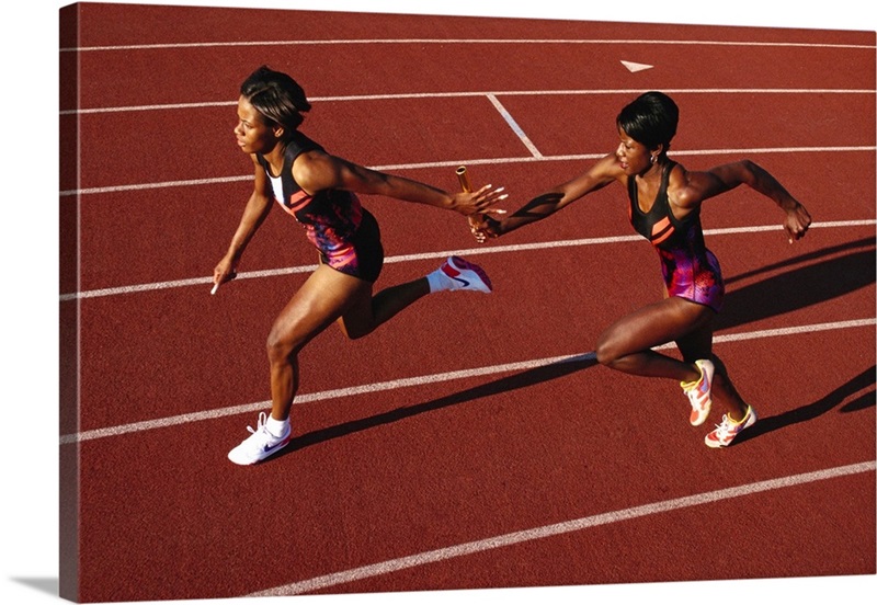 Female runner competing in a relay track race | Great Big Canvas