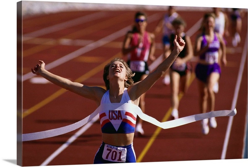 Female runner victorious at the finish line in a track race | Great Big ...