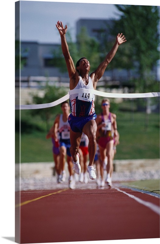 Male runner victorious at the finish line in a track race | Great Big ...