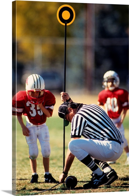 Referee measuring for a first down during a pee wee football game ...