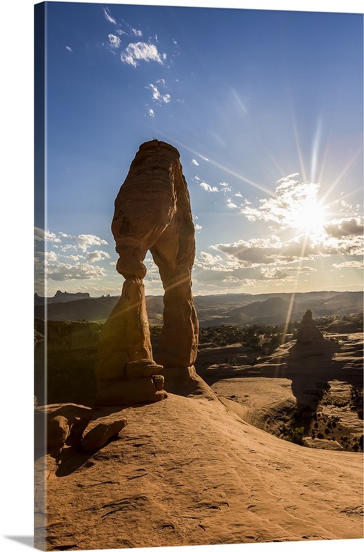 Delicate Arch with sun and clouds at golden hour, Arches National Park ...