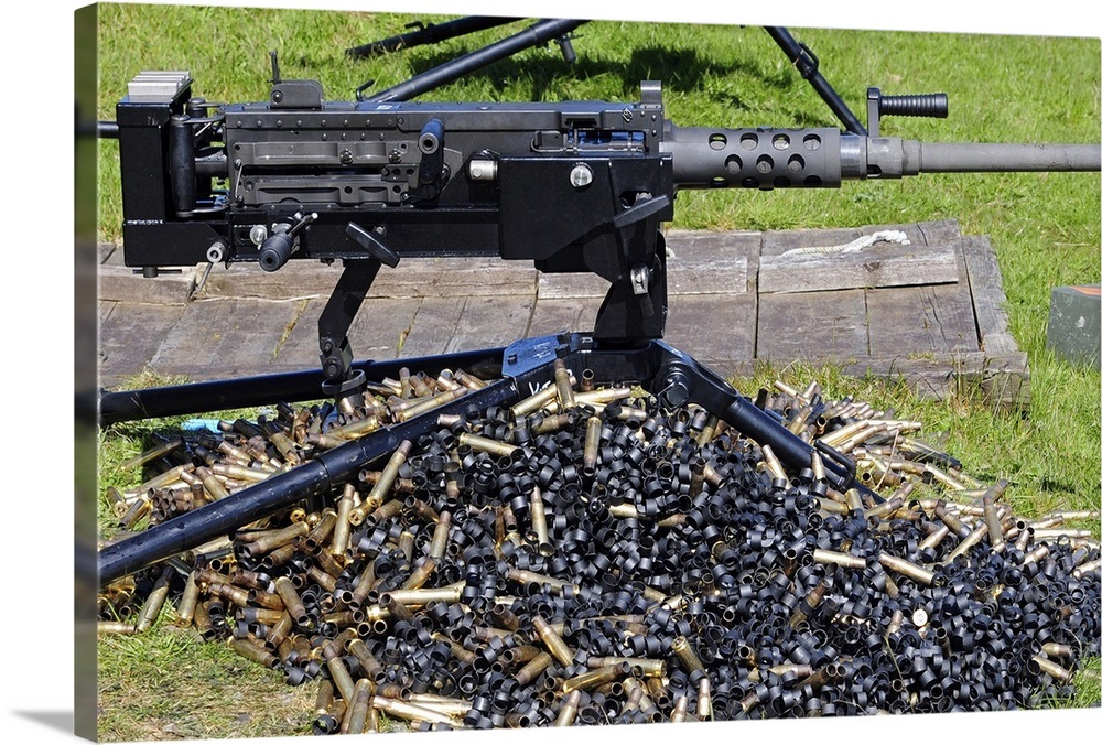 A .50 Caliber Browning Machine Gun with a pile of spent cases and links ...