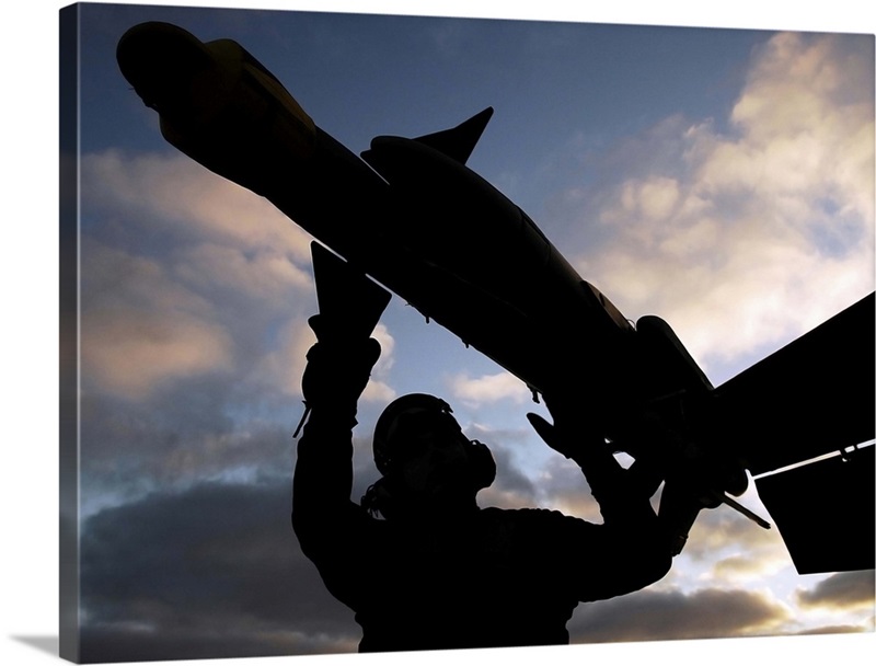 A Sailor inspects a Captive Air Training Missile attached to an F/A18F ...