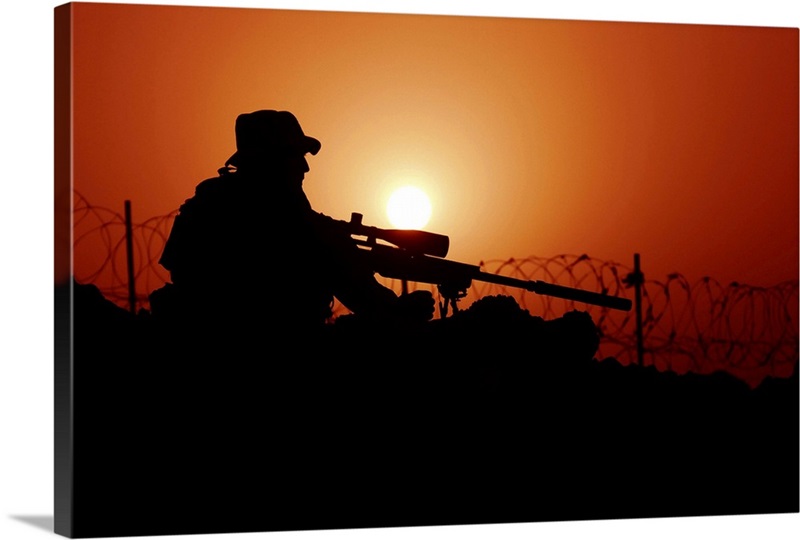 A U.S. Special Forces soldier armed with a Mk-12 Sniper Rifle at sunset ...