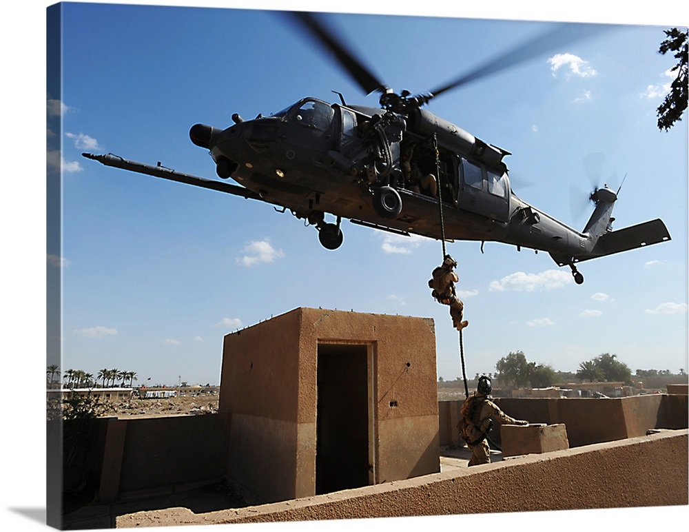 A US Air Force Pararescuemen fast ropes from an HH60 Pavehawk ...