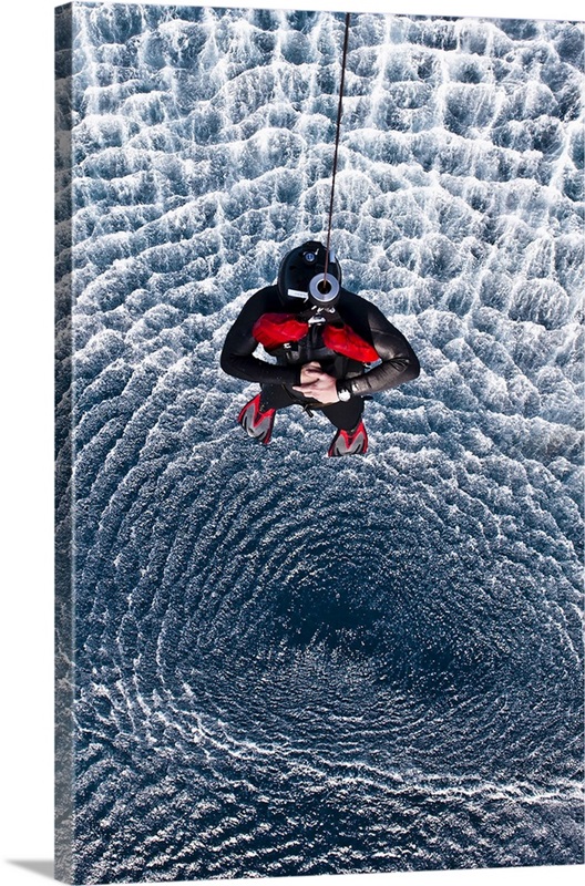 An Explosive Ordnance Disposal Technician is hoisted to an MH-60S Sea ...