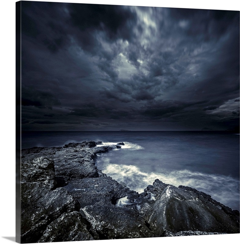 Black rocks protruding through rough seas with stormy clouds, Crete ...