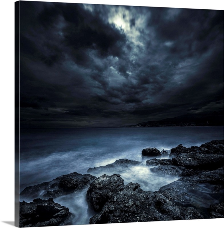 Black rocks protruding through rough seas with stormy clouds, Crete ...
